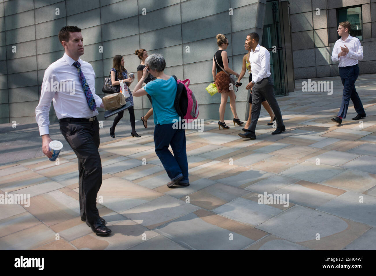 City workers walk along a pedestrian pavement at Broadgate in the City ...