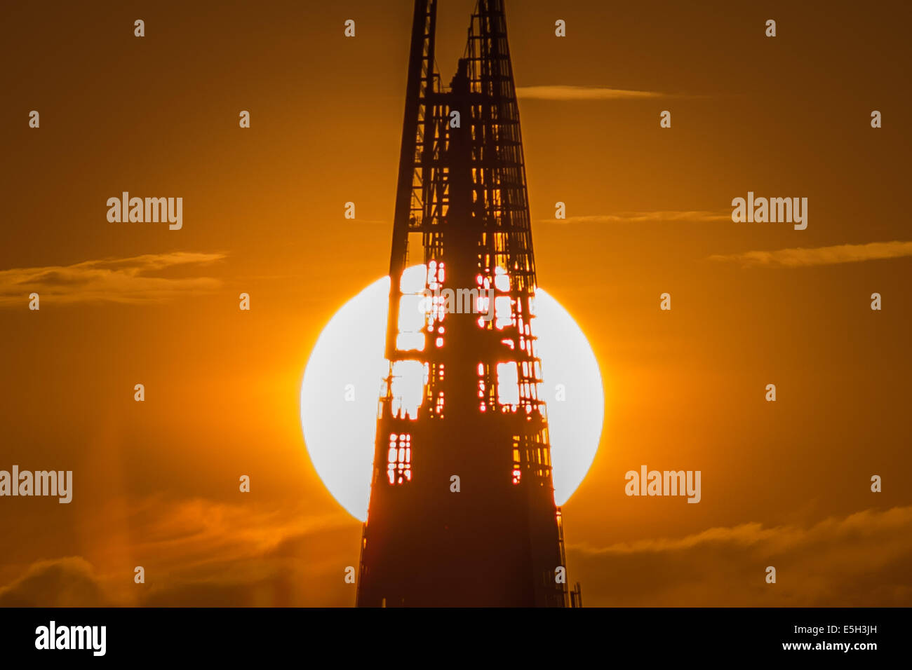 London, UK. 31st July, 2014. Weather: Dramatic split sun during sunset ...