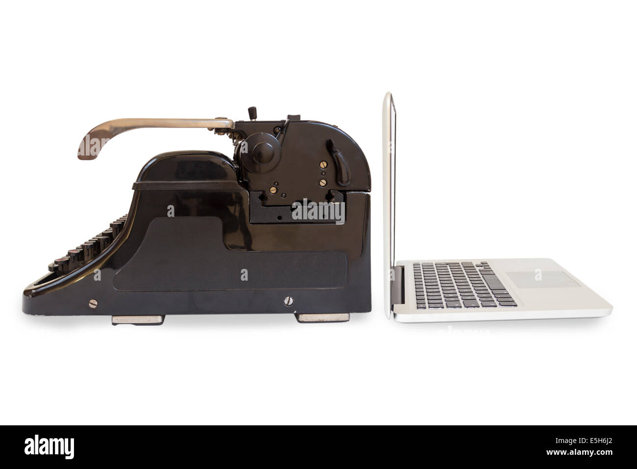 Modern silver laptop and an old black typewriter isolated on white ...