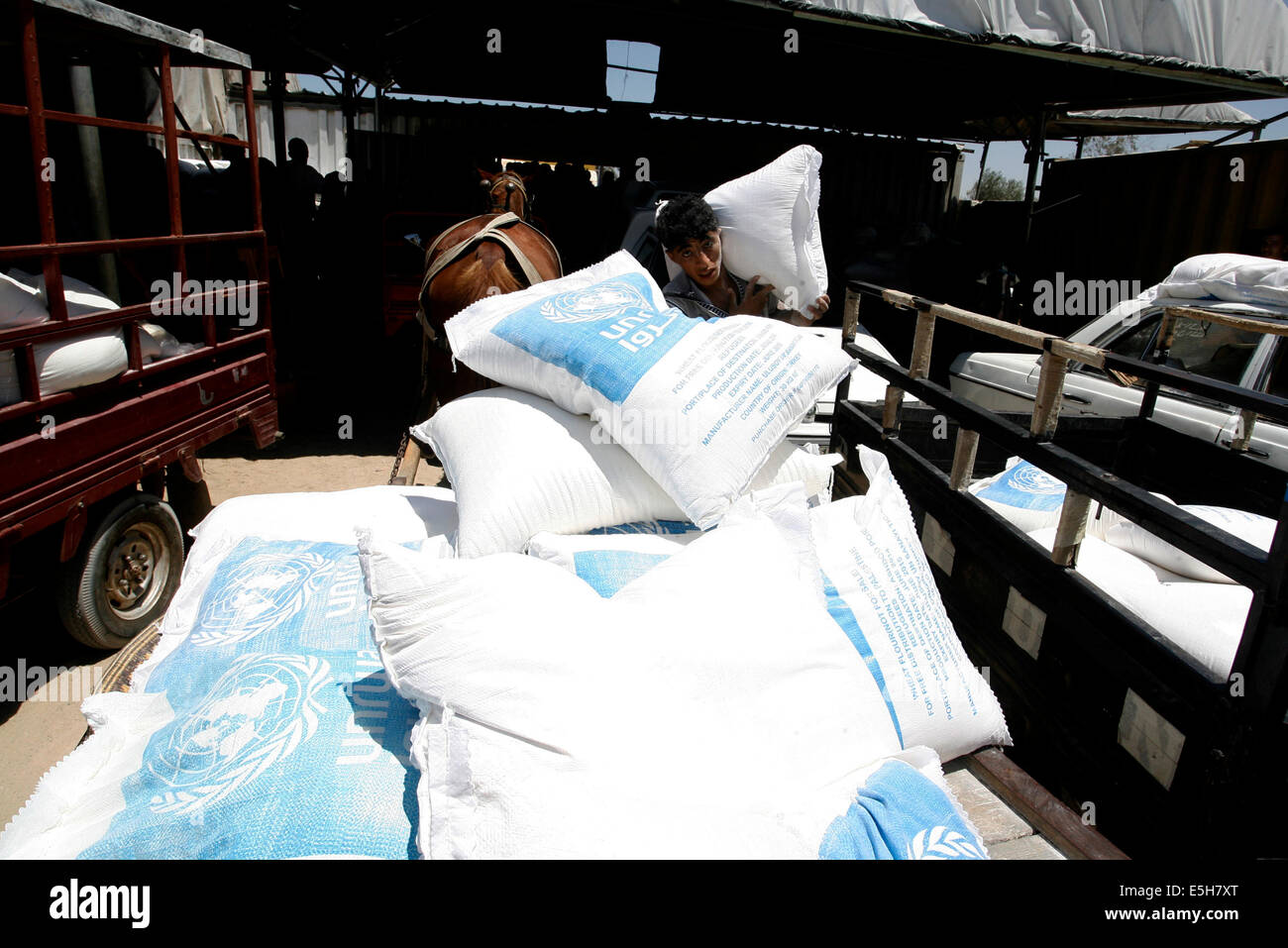 Palestinians receive their monthly food aid at a United Nations ...
