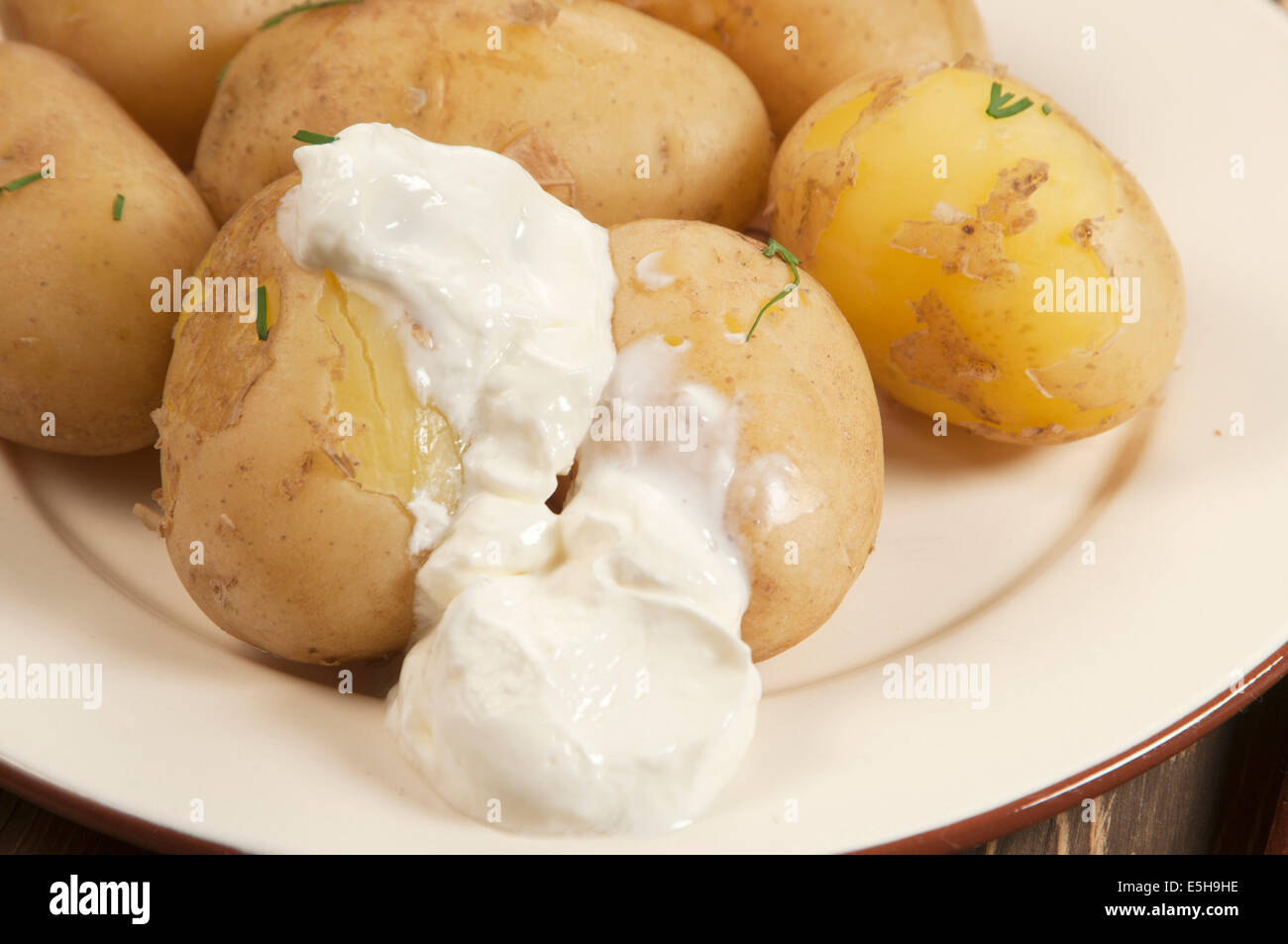 Boiled Young potatoes with sour cream on a plate Stock Photo - Alamy