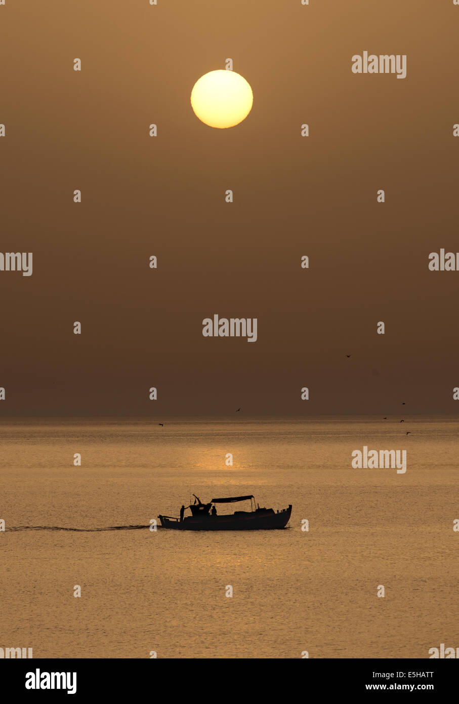 Caique (traditional fishing boat) sets out at dawn from Azolimnos ...