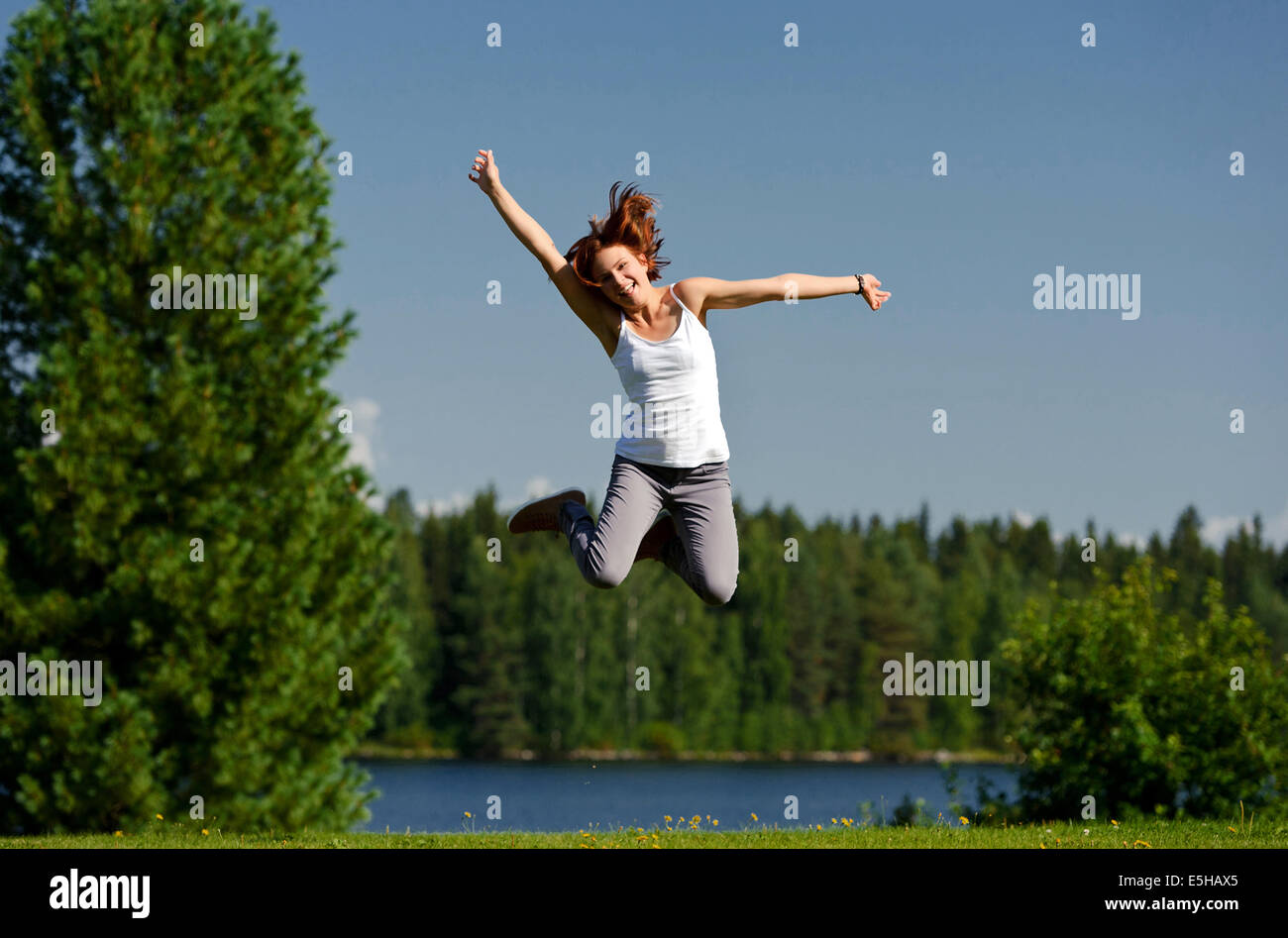 Young woman jumping outside Stock Photo - Alamy