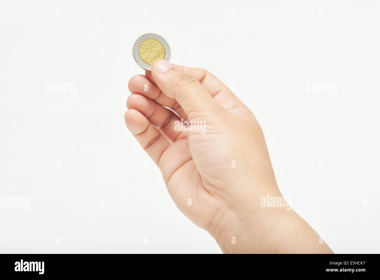 Hand holding one coin with finger to pay cash Stock Photo - Alamy