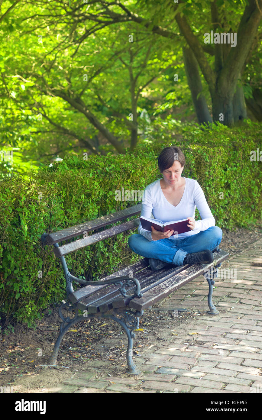 Woman park bench alone reading hi-res stock photography and images - Alamy