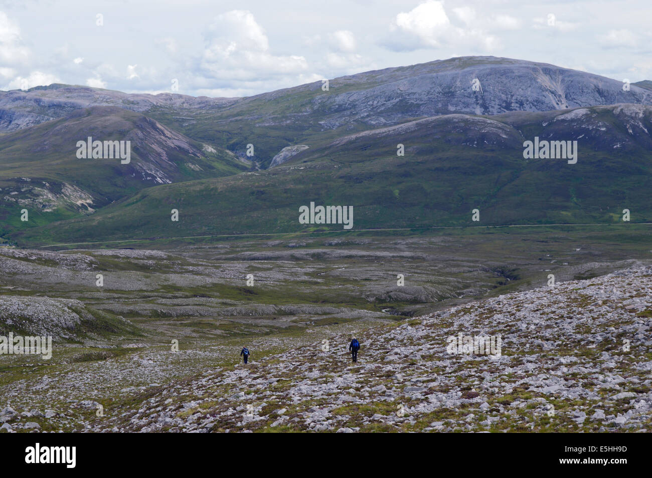 Two hill walkers heading down the Scottish Mountain Canisp with Breabag ...