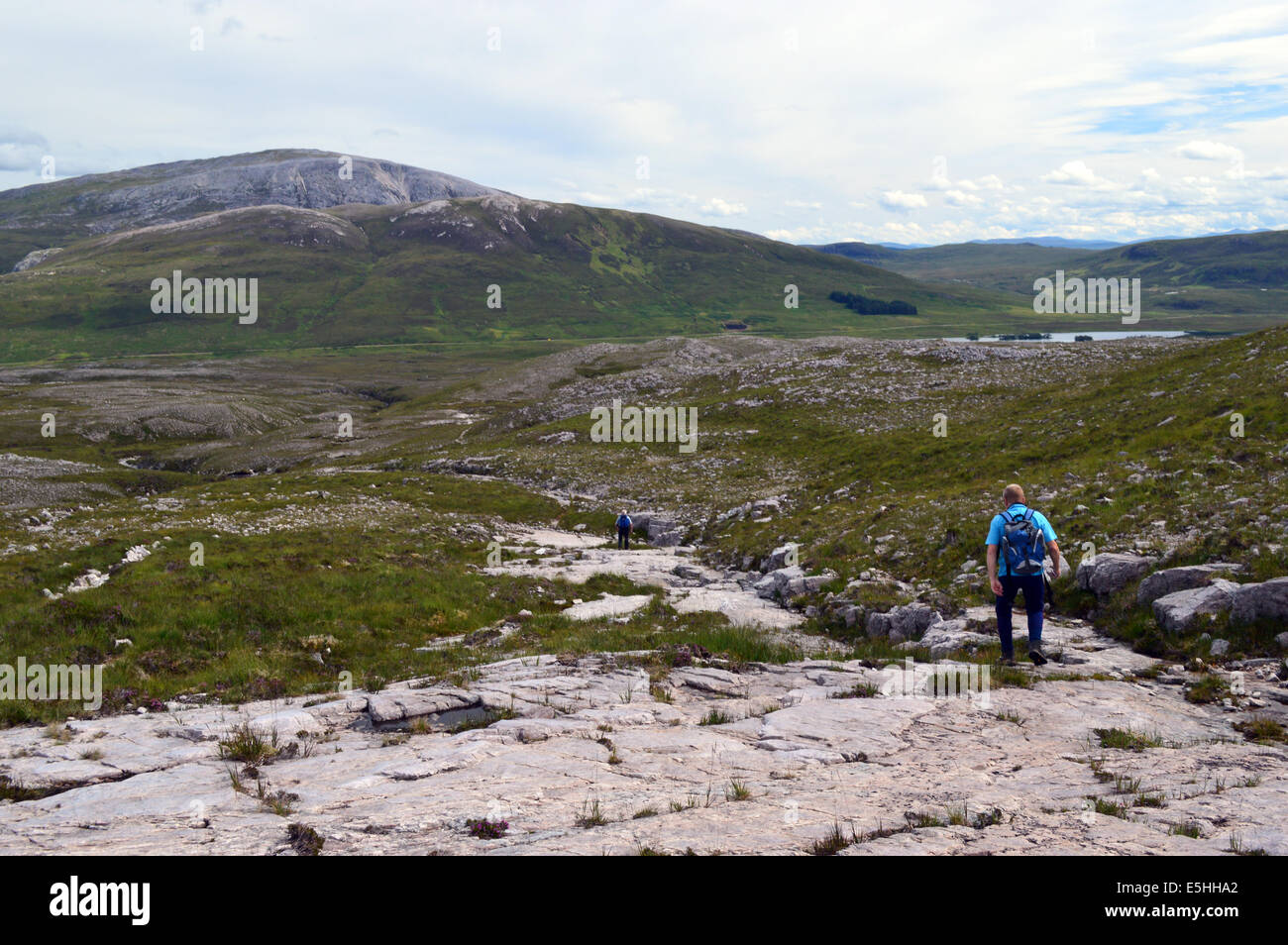 Male Hill walker heading down the Scottish Mountain Canisp with Breabag ...