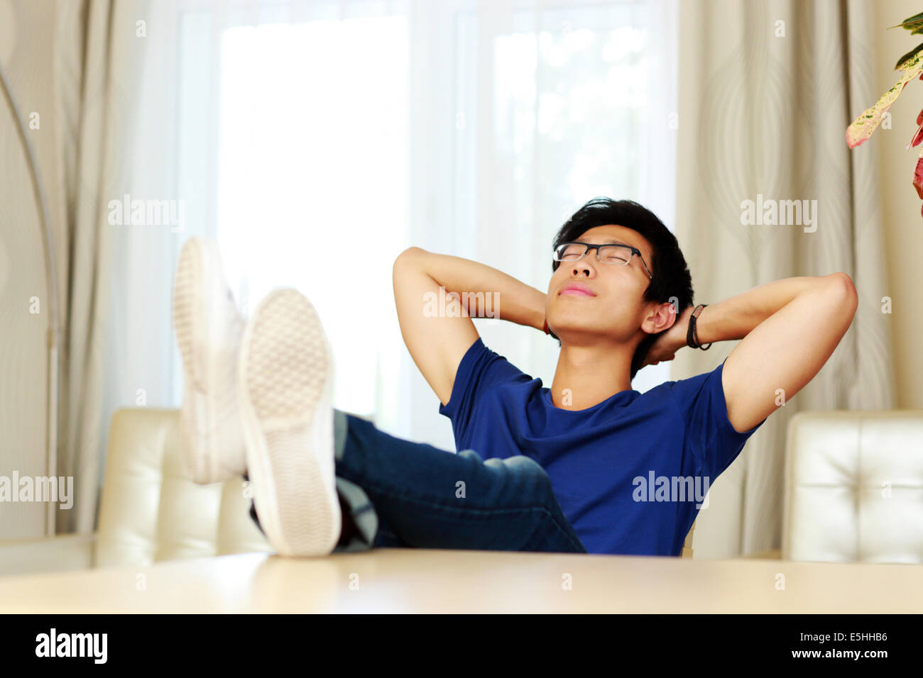 Asian man relaxing at home Stock Photo - Alamy