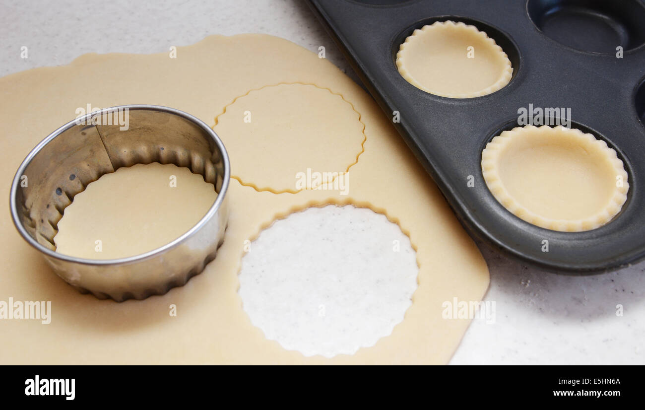 Cutting large circles of pastry to line a bun tin Stock Photo - Alamy