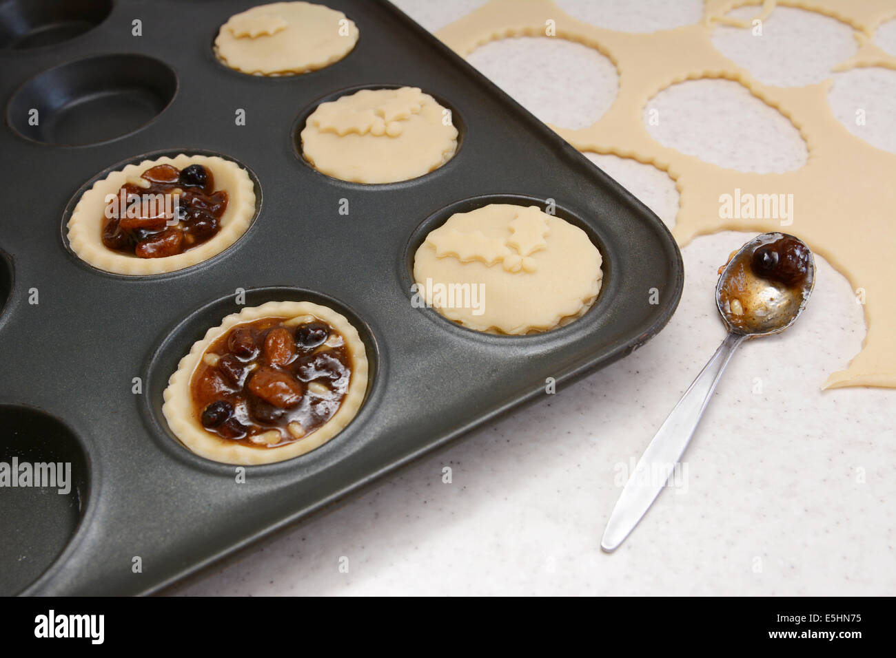 Making mince pies, with rolled out pastry scraps and teaspoon of ...