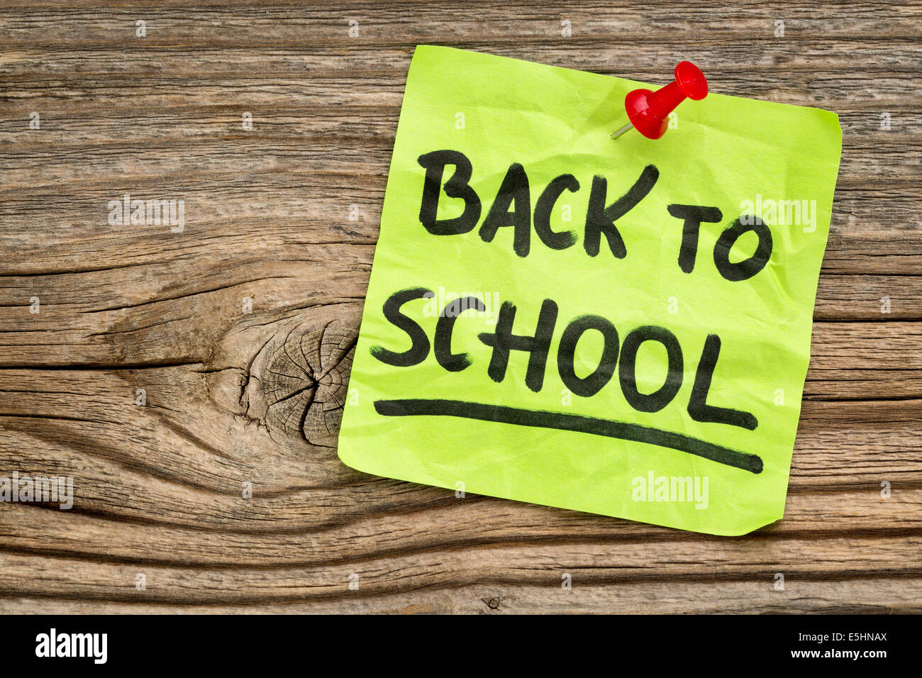 back to school reminder - handwriting on a green sticky note against ...