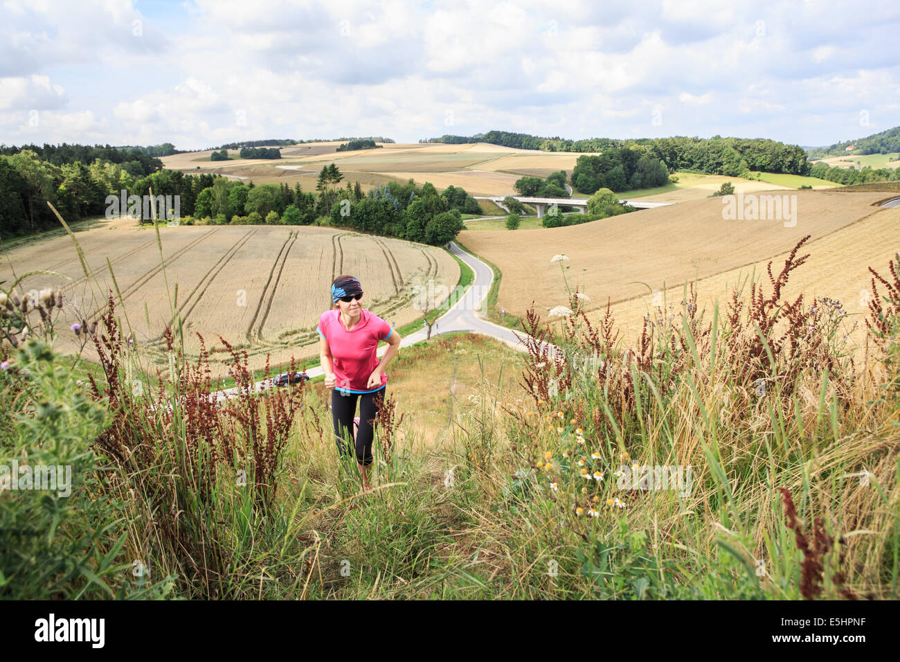 a woman running through the rural landscape Stock Photo - Alamy