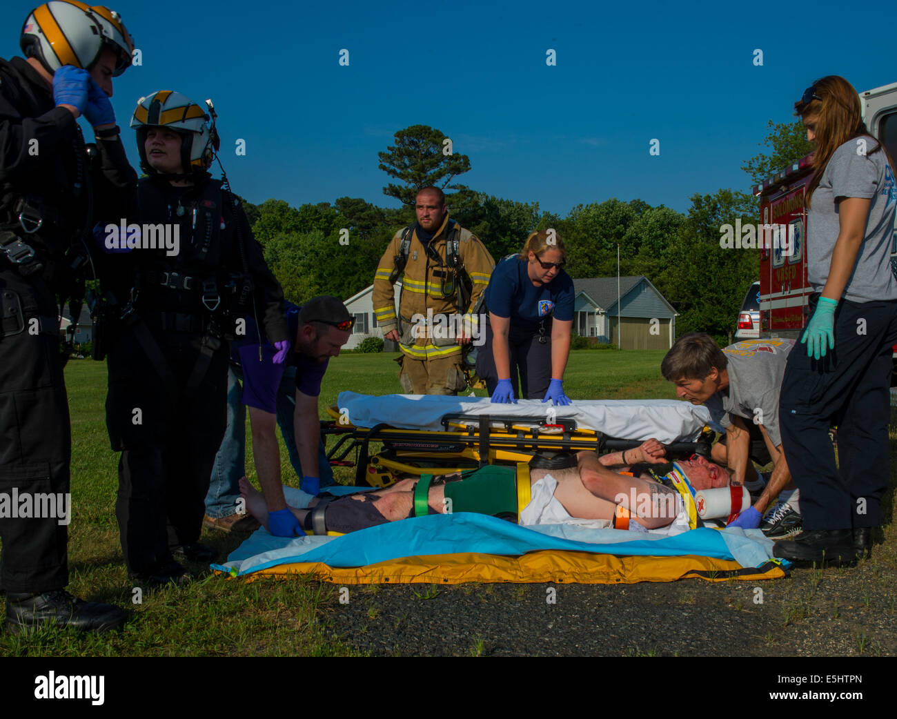 Local fire and EMS units package the patient for transport, June, 16 ...
