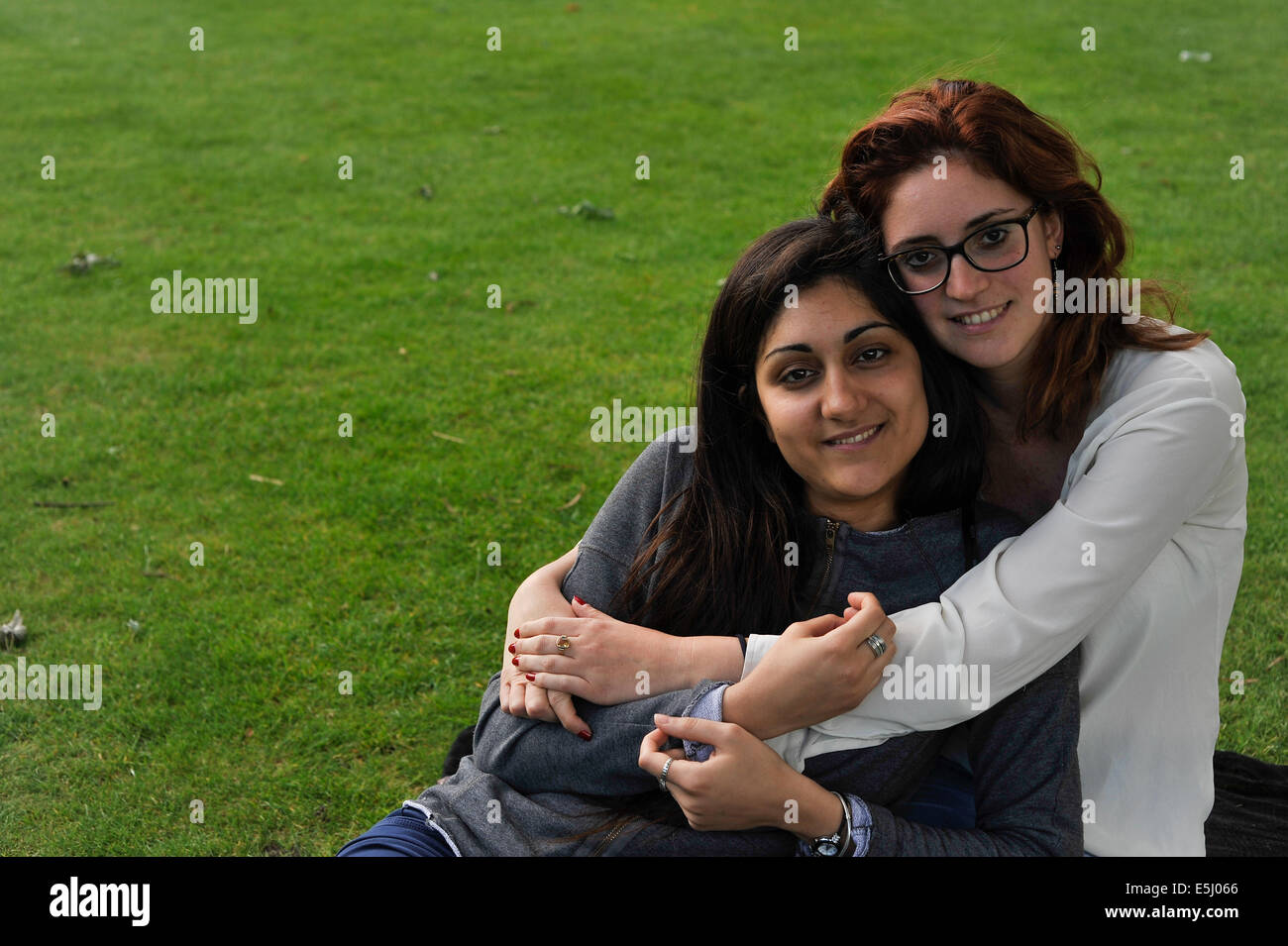 Two women hugging and smiling looking at the camera Stock Photo - Alamy