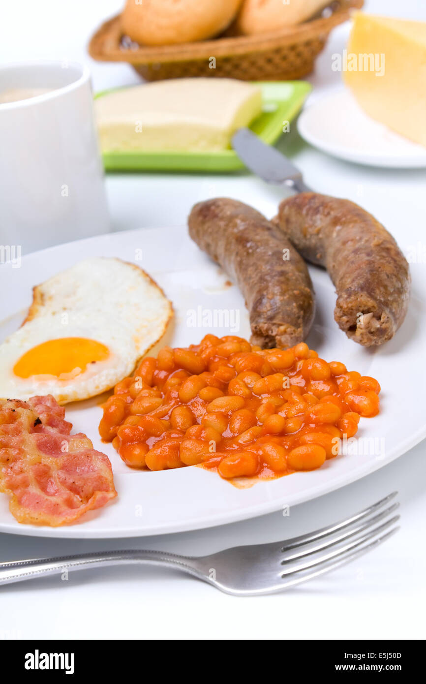 a traditional english breakfast - egg, sausages, beans and bacon - with ...