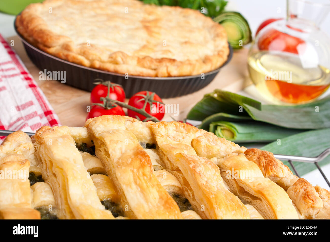 two pies - open and closed with tomatoes, leek and oil at the back ...