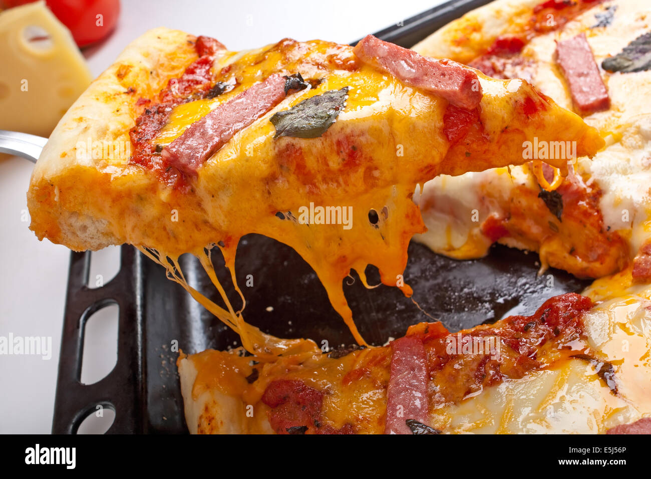 Slice of Ham Pizza with Melted Cheese Lifted Up Stock Photo - Alamy