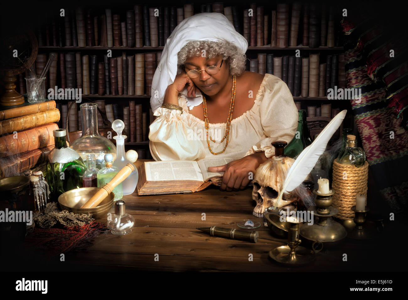 Female alchemist studying in her books at night Stock Photo - Alamy