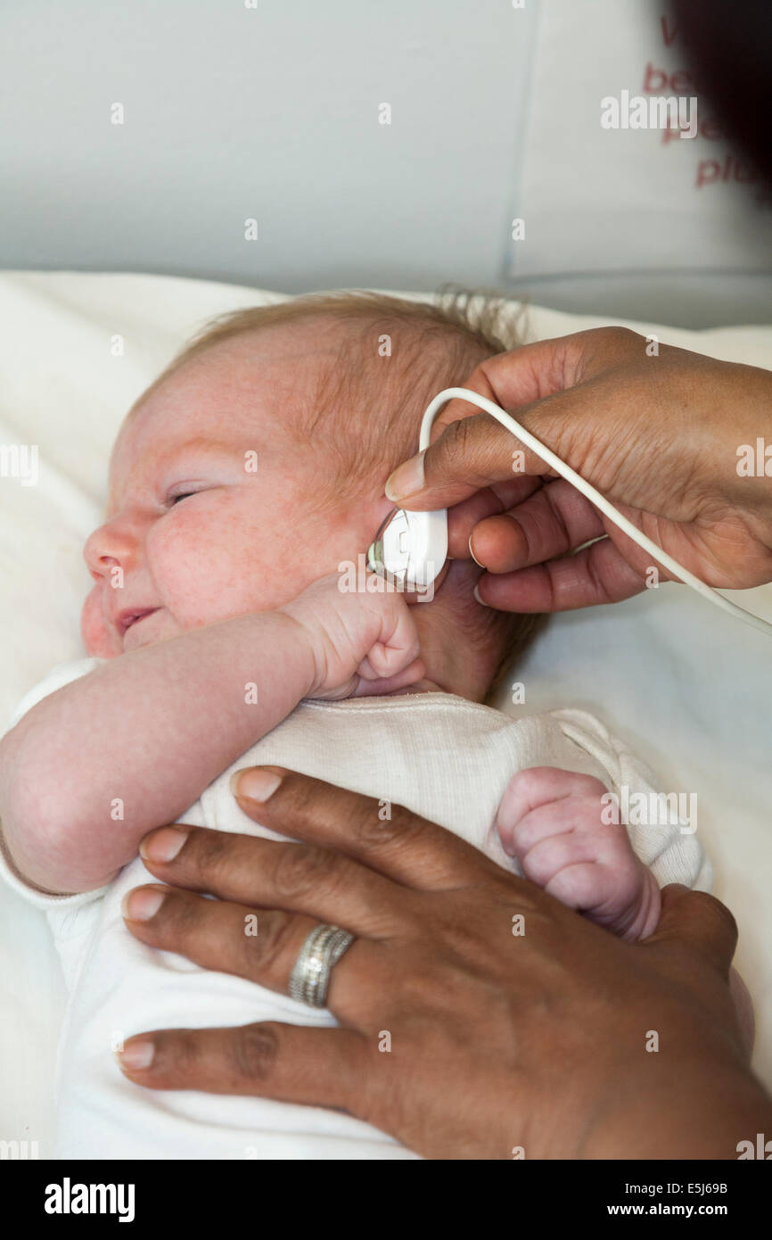 Newborn / new born baby undergoes a neonatal hearing screening test ...