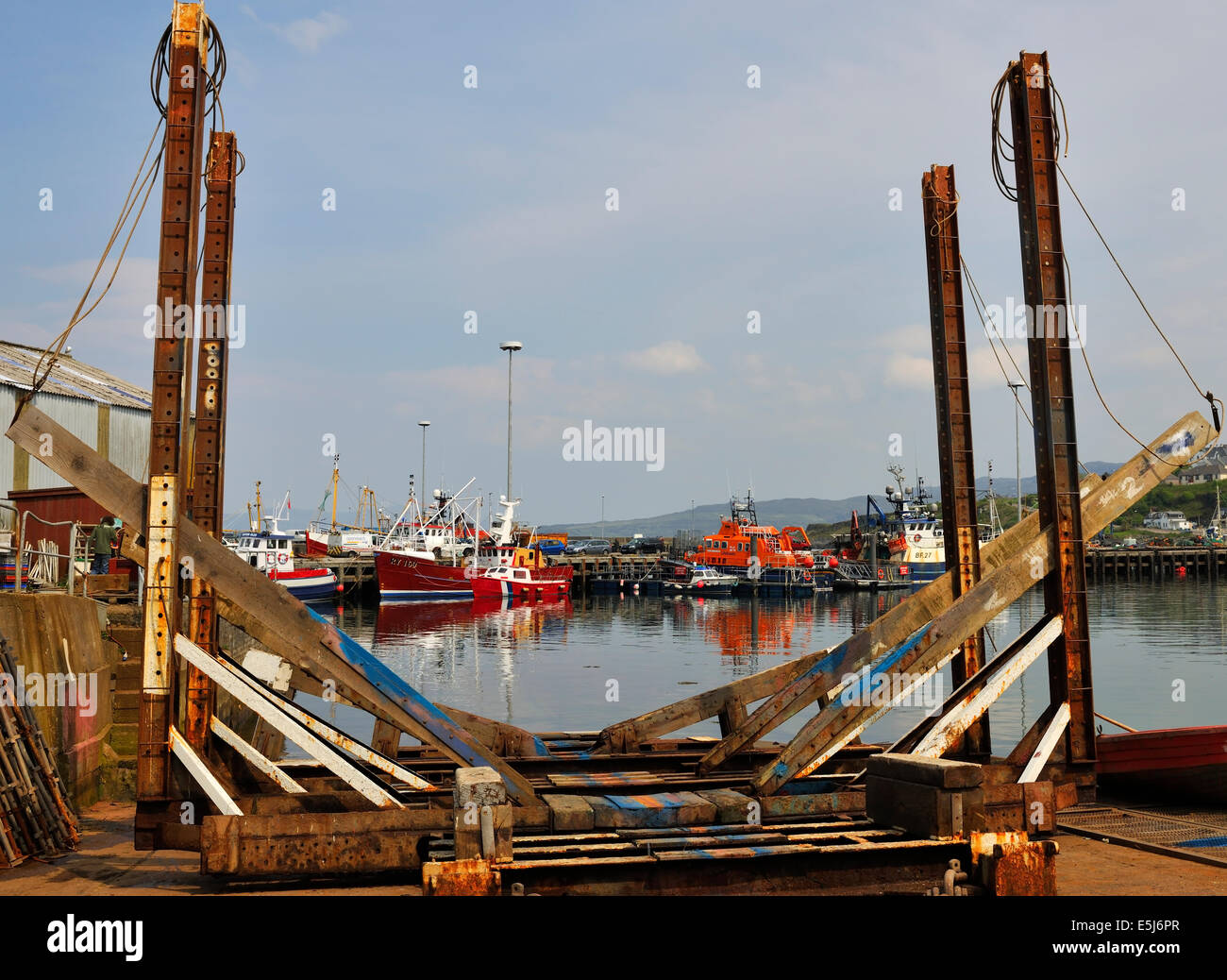 Boats framed by a ship's cradle in Mallaig harbour, Scotland Stock ...