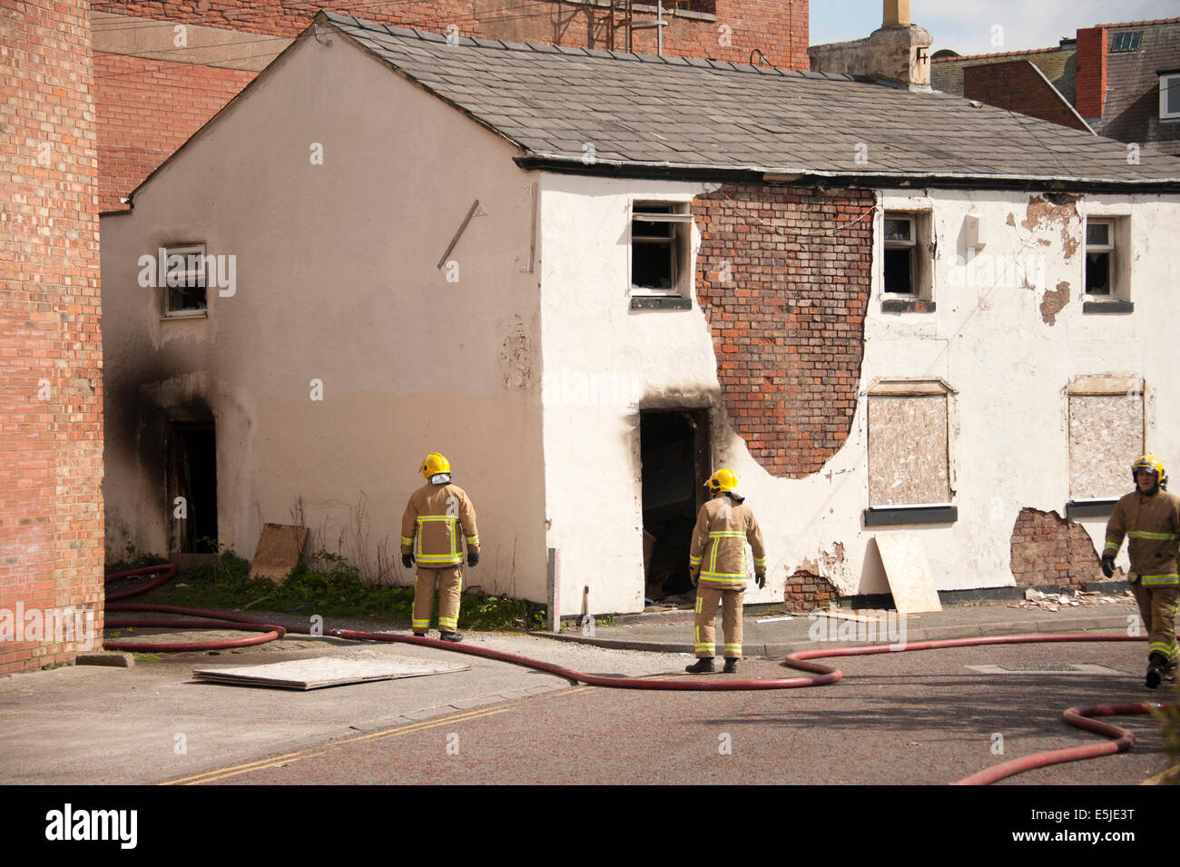 Firefighters at derelict house building fire Stock Photo - Alamy