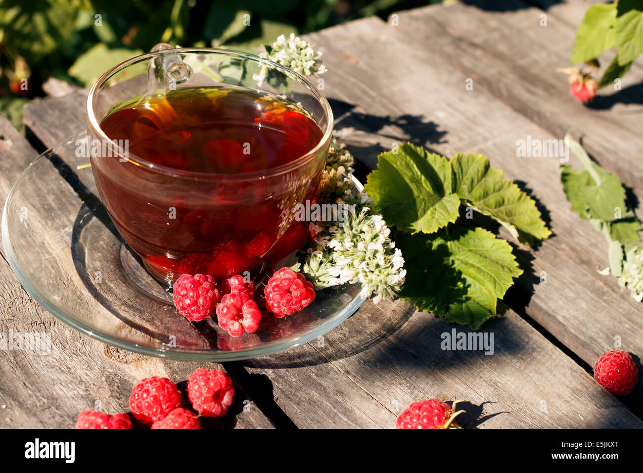 raspberry tea in transparent teacup on wooden desks Stock Photo - Alamy