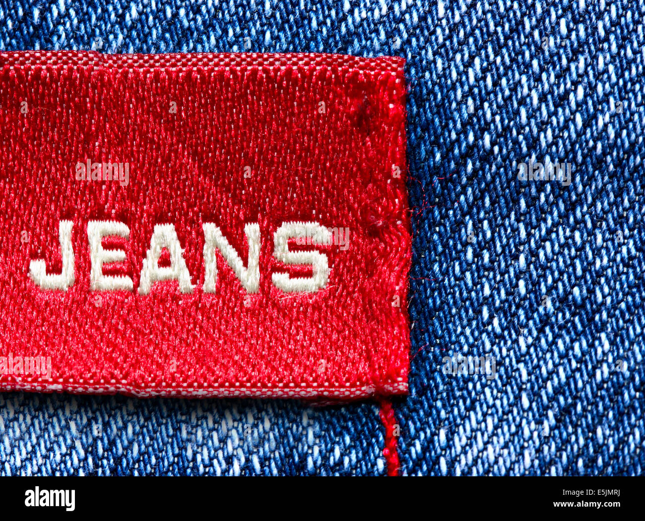 Blue jeans and red label with word Jeans Stock Photo - Alamy