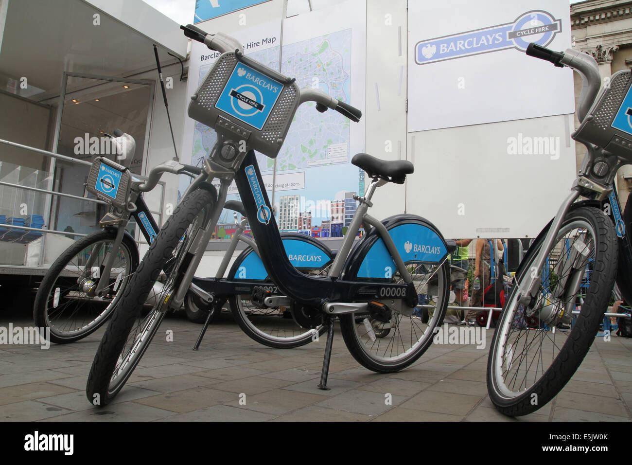 London, UK 2 August 2014. Boris bikes seen by a stall with a large map ...