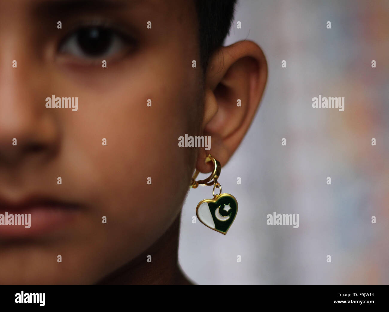 Pakistani shopper wears an earring with Pakistan's national flag accent ...
