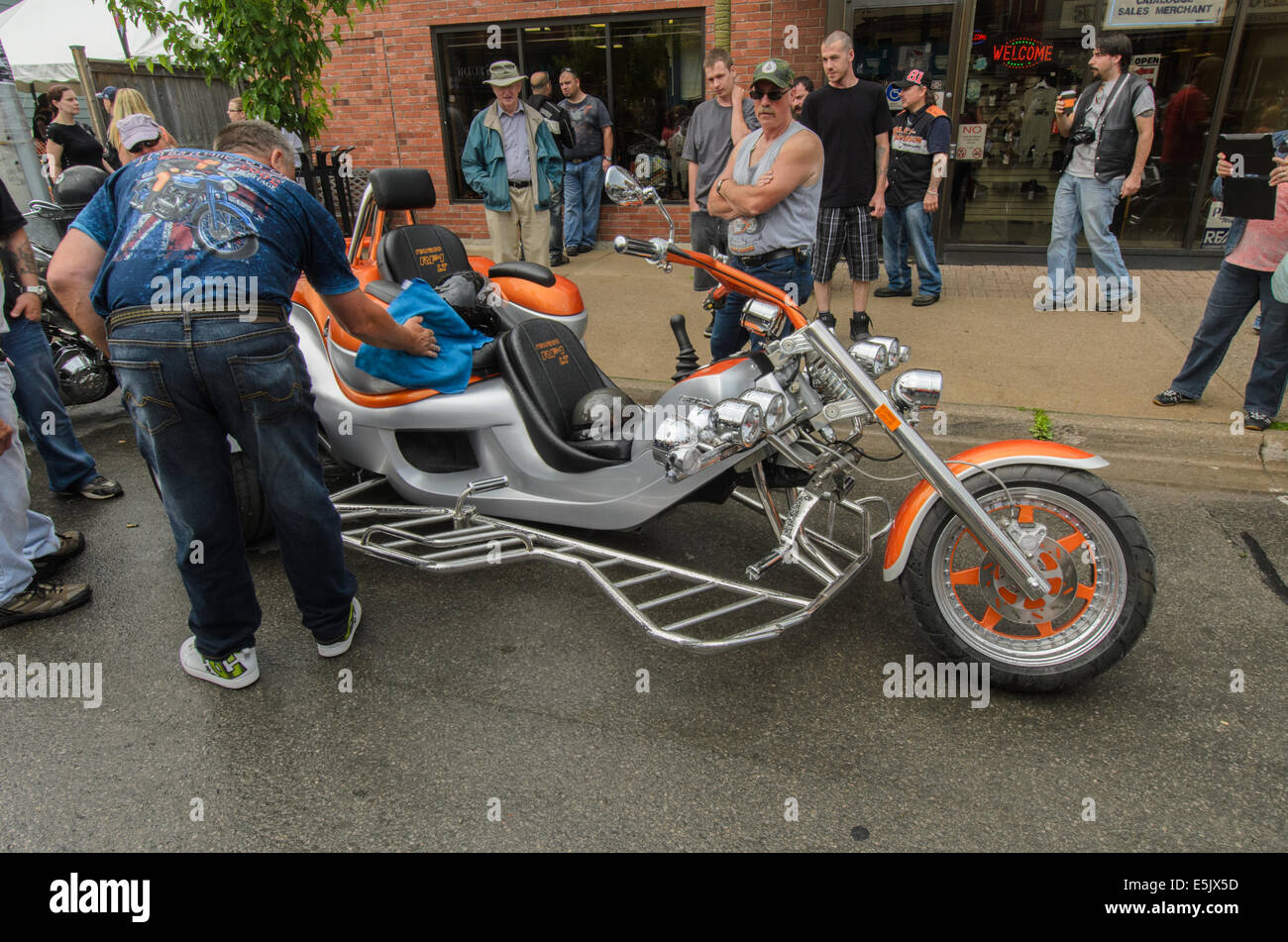 A proud owner wiles the raindrops off his highly customized motorcycle ...
