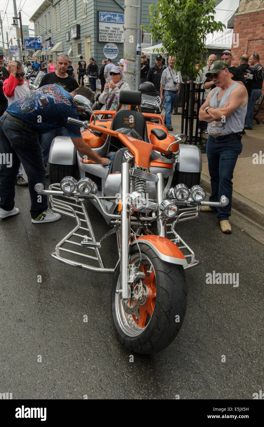 A proud owner wiles the raindrops off his highly customized motorcycle ...