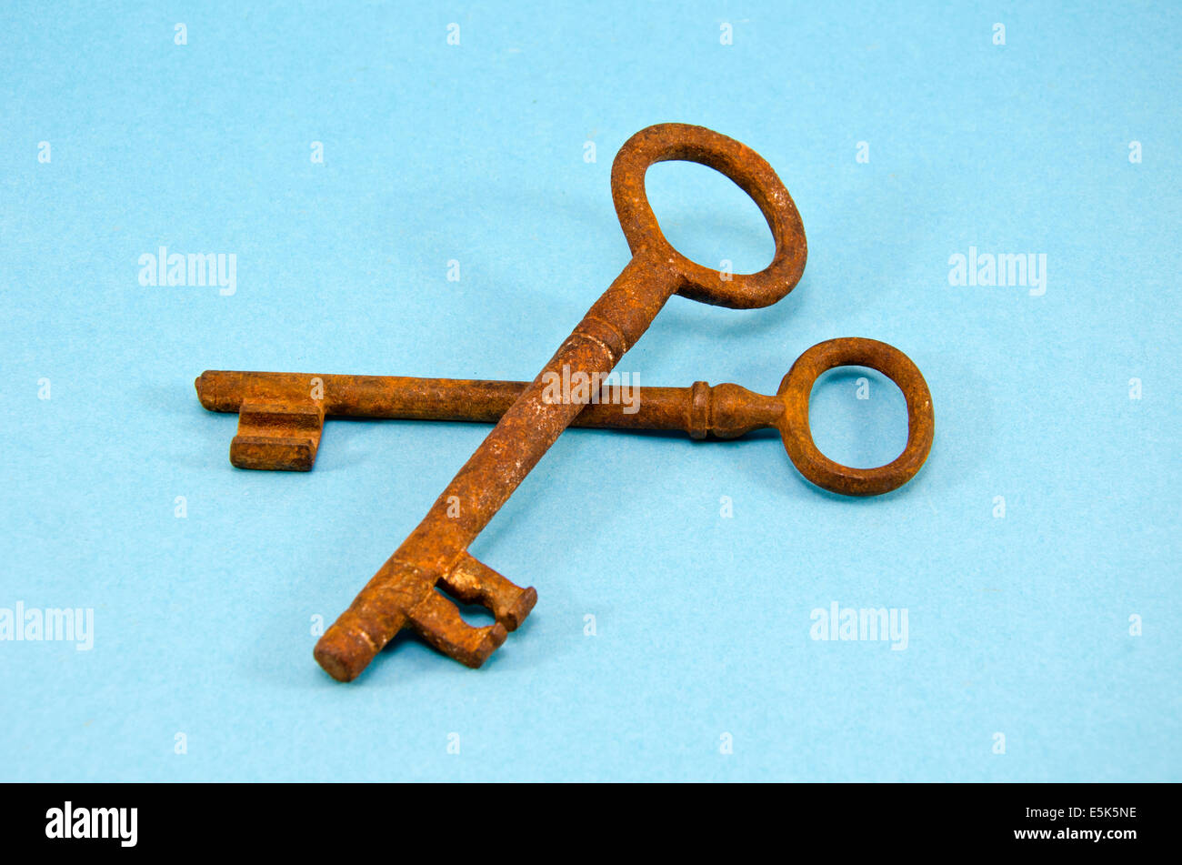 two antique rusty metal key on blue background Stock Photo - Alamy