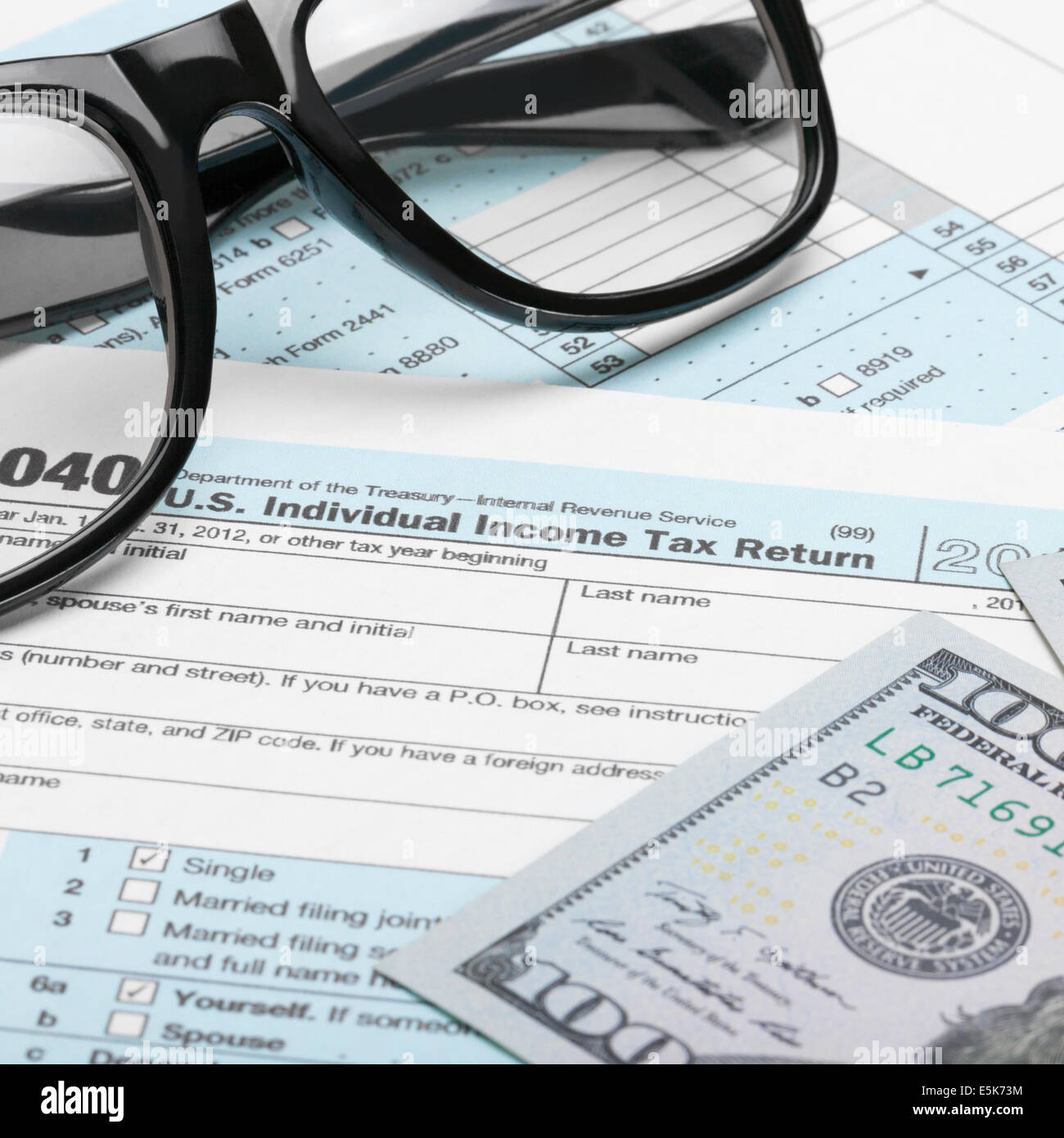 Tax Form 1040 with dollars and glasses - 1 to 1 ratio Stock Photo - Alamy