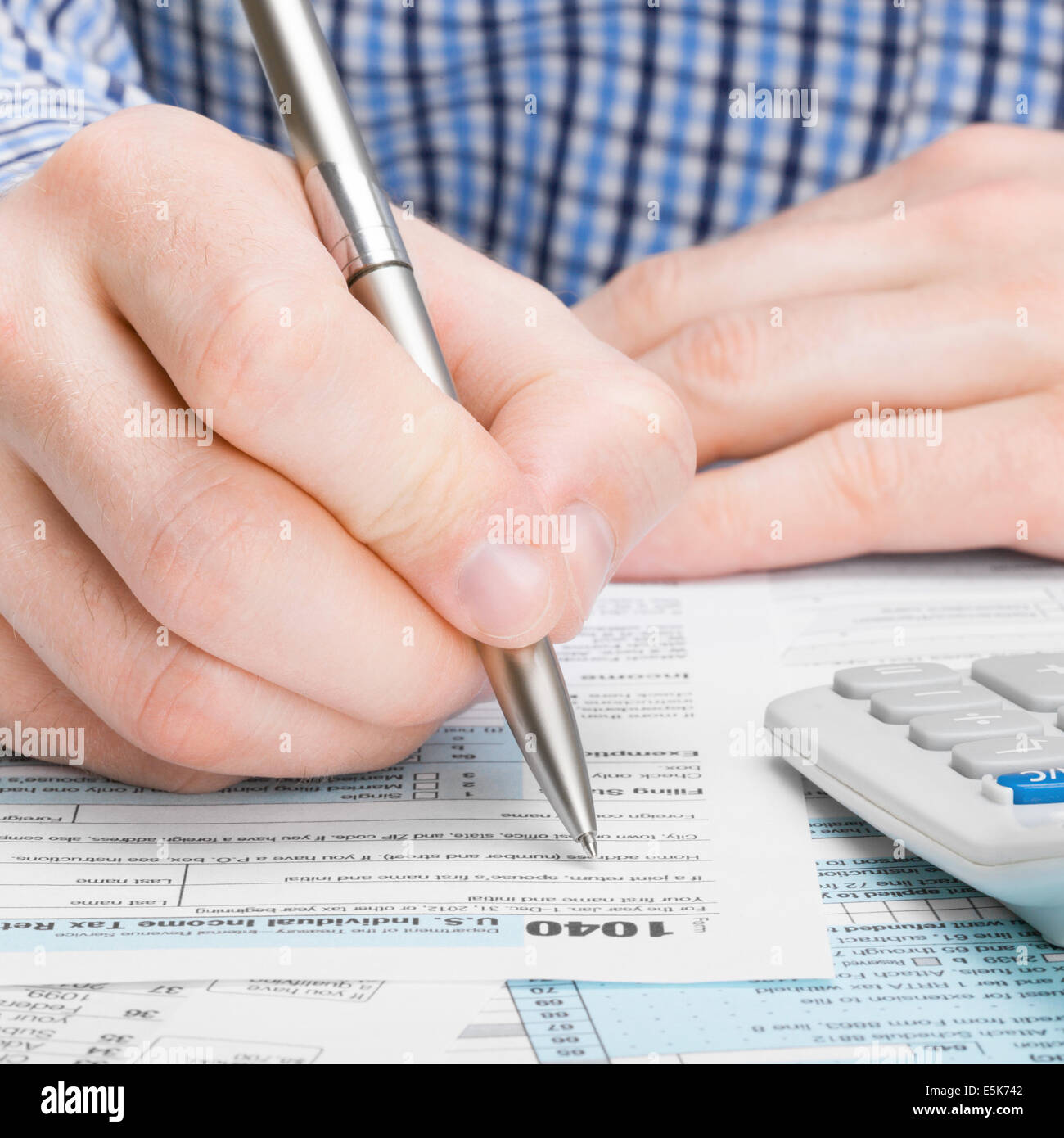 Tax Form 1040 - male filling out tax form - 1 to 1 ratio Stock Photo ...