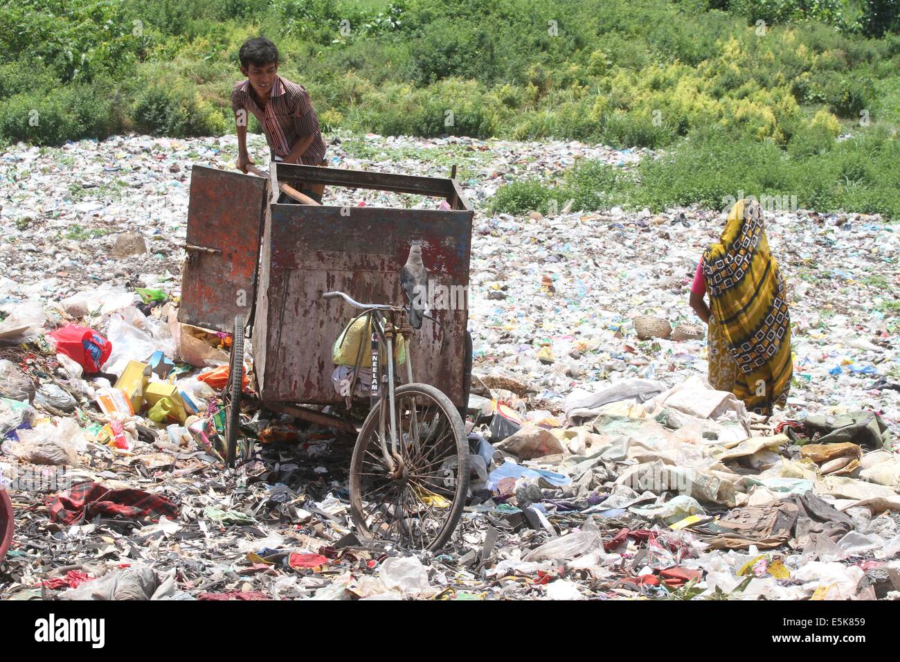 Dhaka, Bangladesh, 03 August 2014.A woman searches through garbage to ...