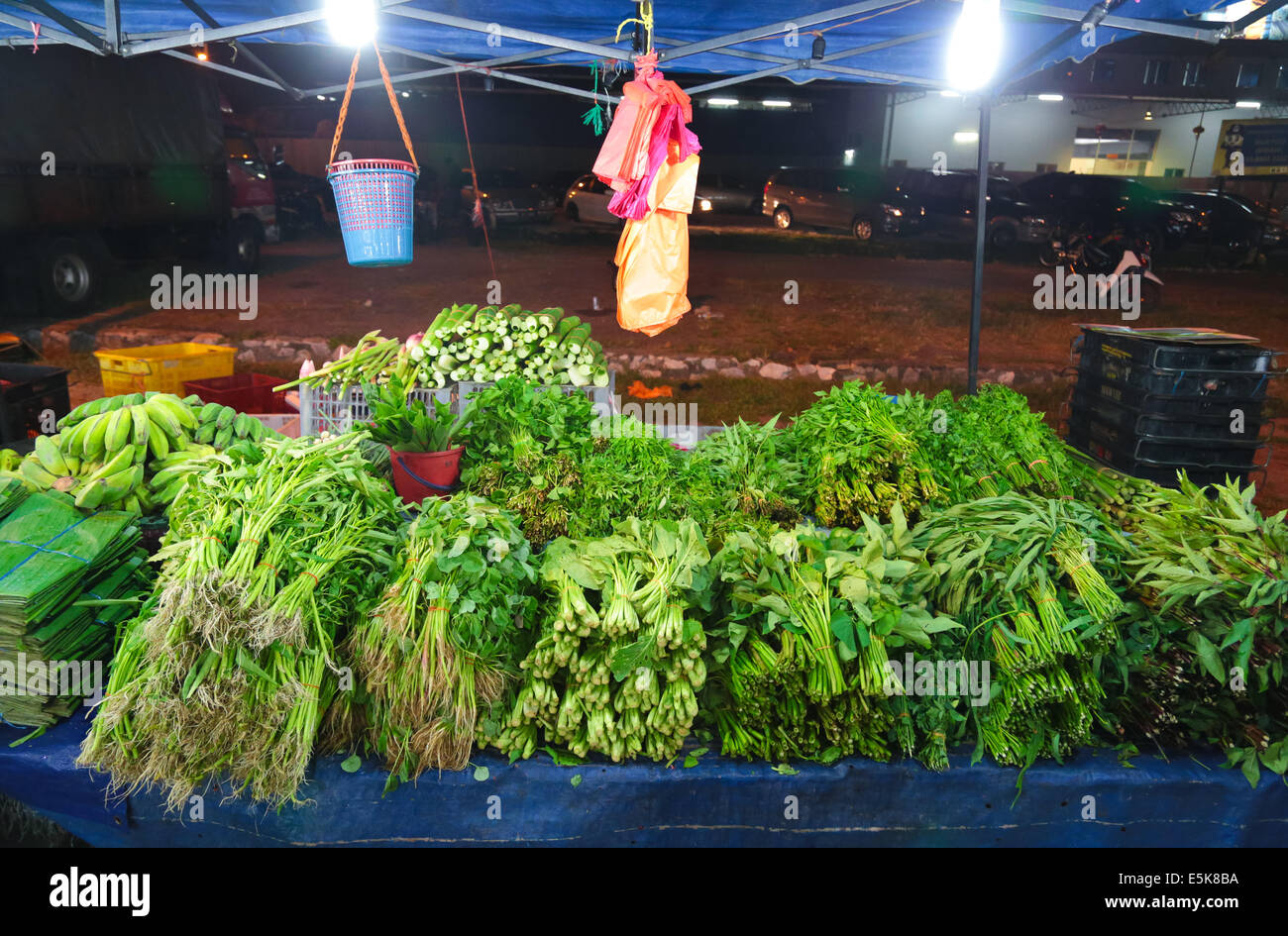 Outdoor night hawker stall selling variety of fresh vegetables etc ...