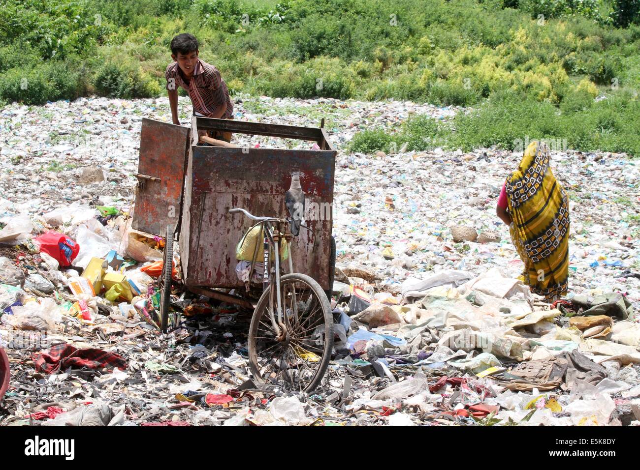 Dhaka, Bangladesh, 03 August 2014.A woman searches through garbage to ...