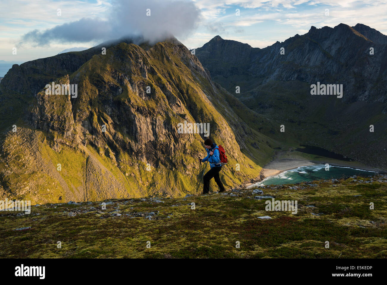 Female hiker hiking towards summit of Ryten with Kvalvika beach in ...