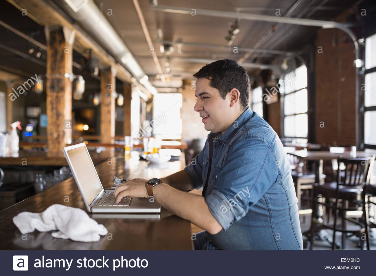 Pub owner working at laptop Stock Photo - Alamy