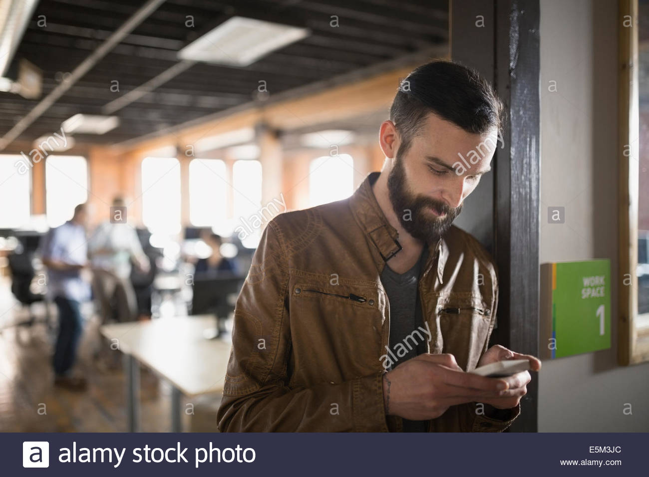Businessman using cell phone in office Stock Photo - Alamy