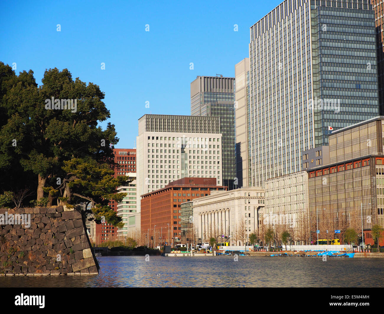 Ancient stone walls of the Tokyo Imperial Palace contrasting the modern ...