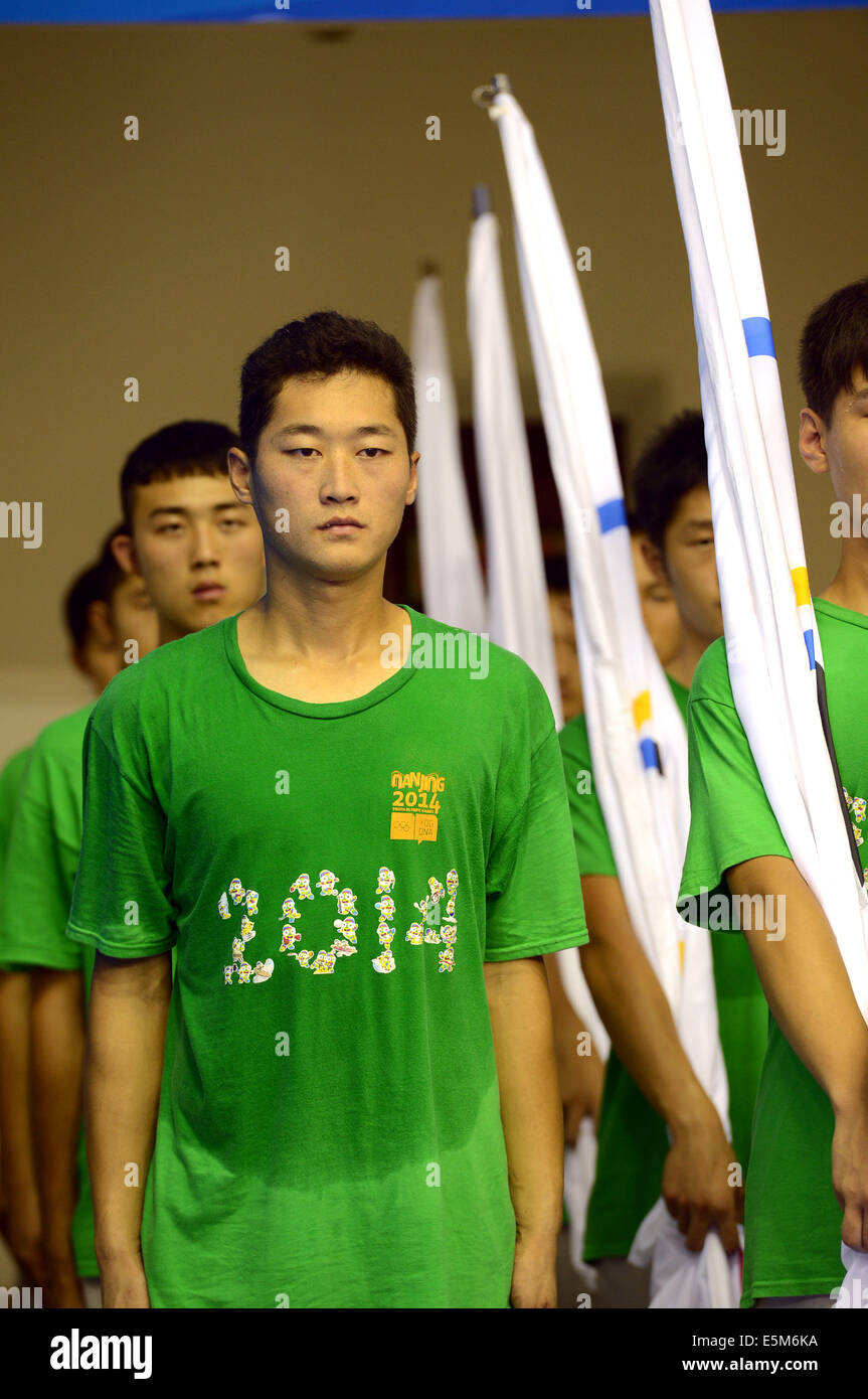 Beijing, China. 4th Aug, 2014. A volunteer stands straight and sweats ...