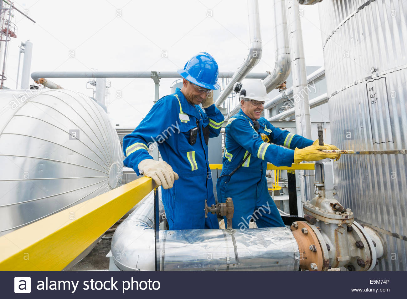 Two men turning valve hi-res stock photography and images - Alamy