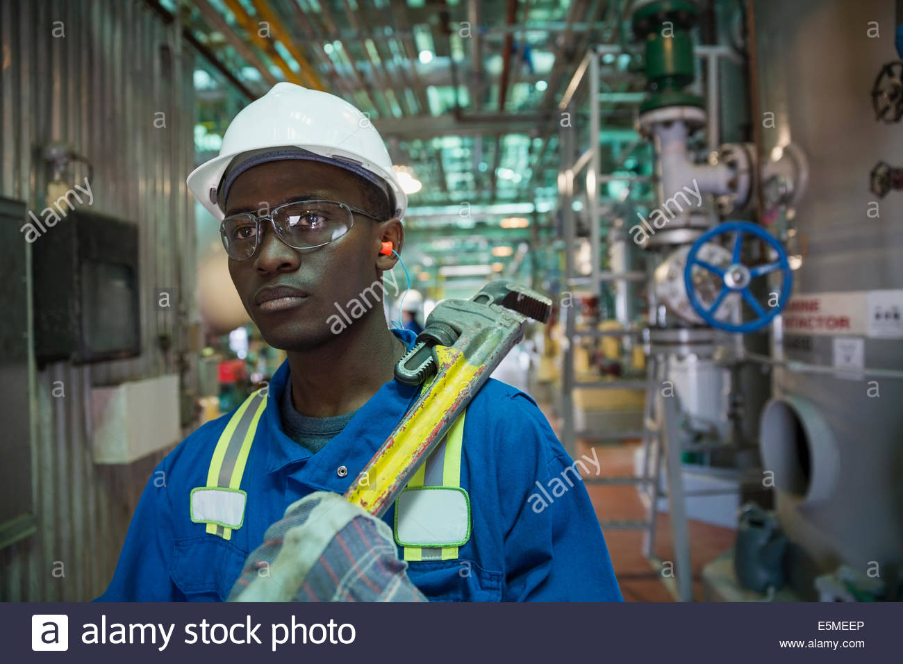 Male worker with pipe wrench in gas plant Stock Photo - Alamy