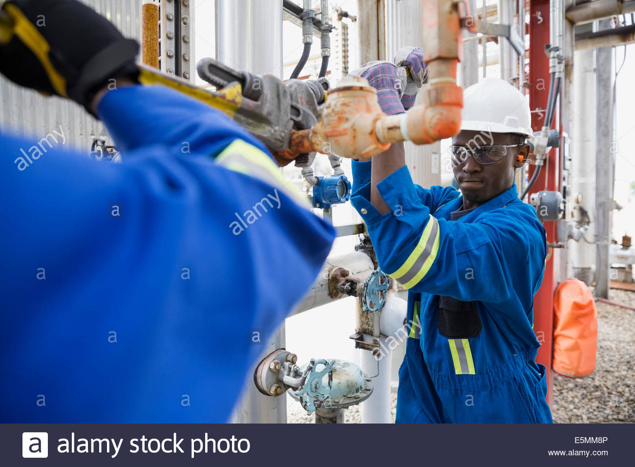 Workers repairing pipe at gas plant Stock Photo - Alamy