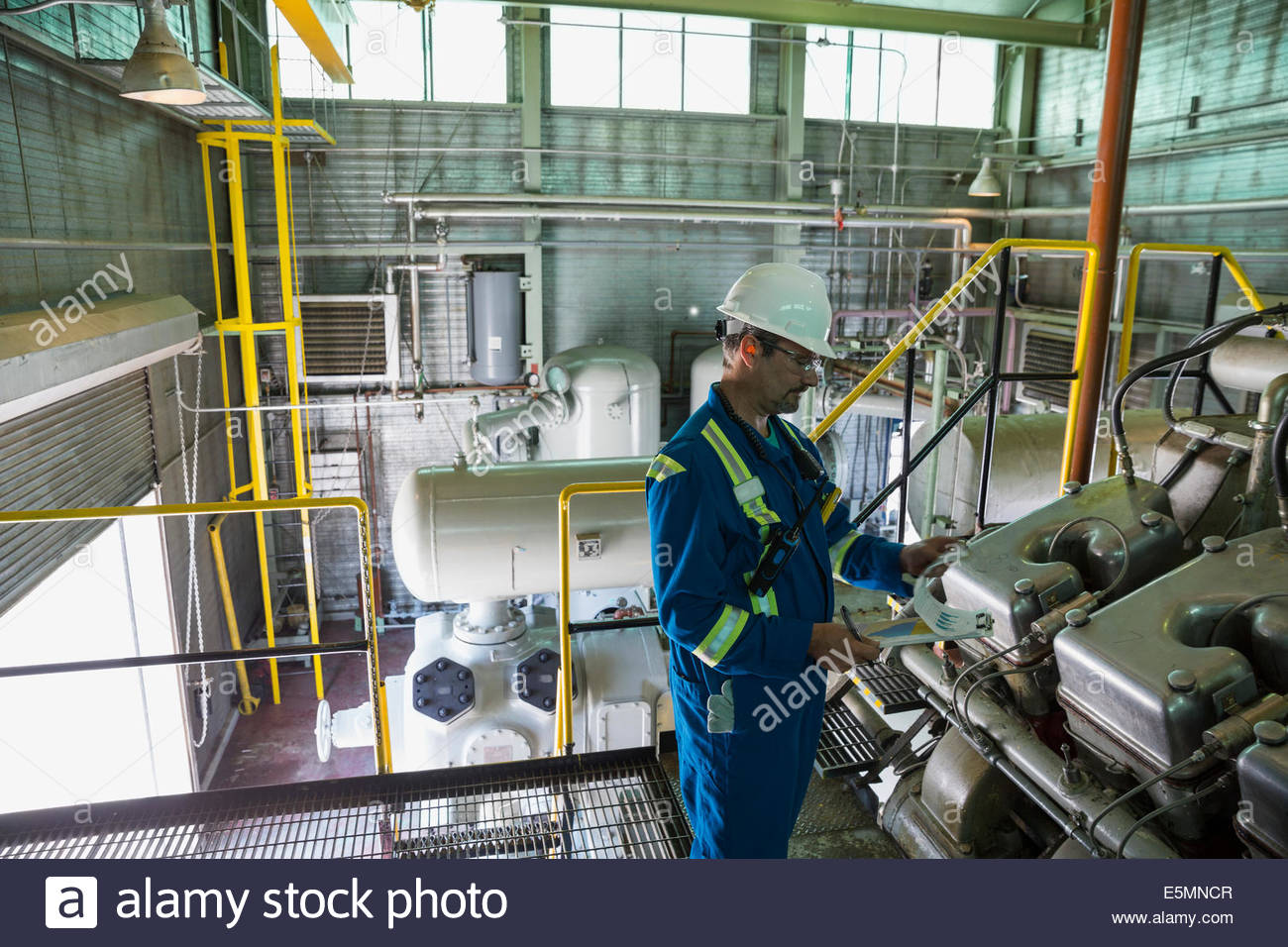 Male worker checking equipment in gas plant Stock Photo - Alamy