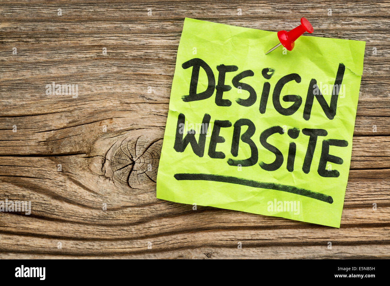 design website reminder - handwriting on a green sticky note against ...