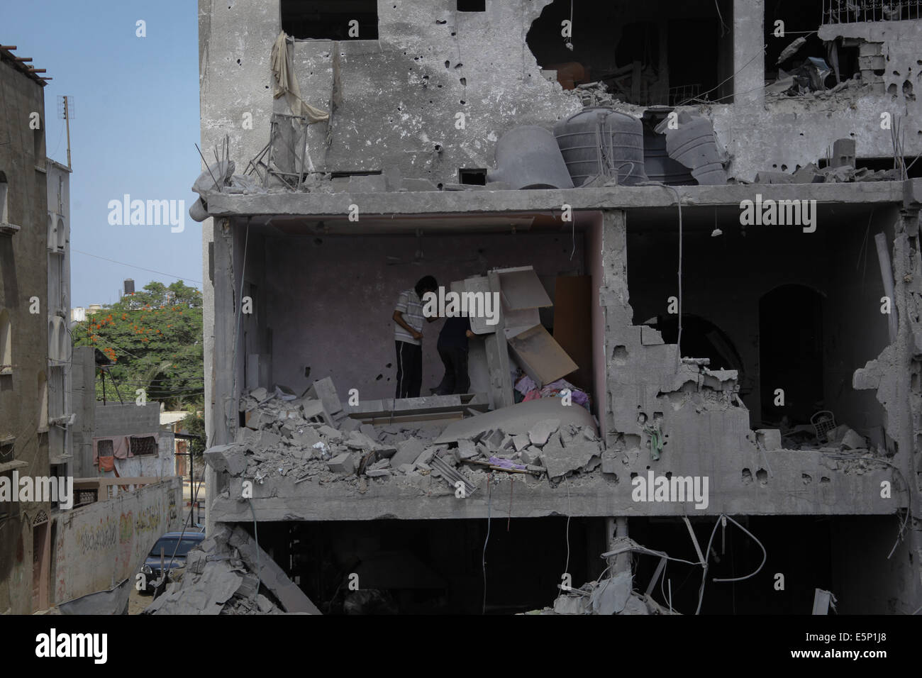 Gaza. 4th Aug, 2014. Palestinians inspects a destroyed house in Beit ...