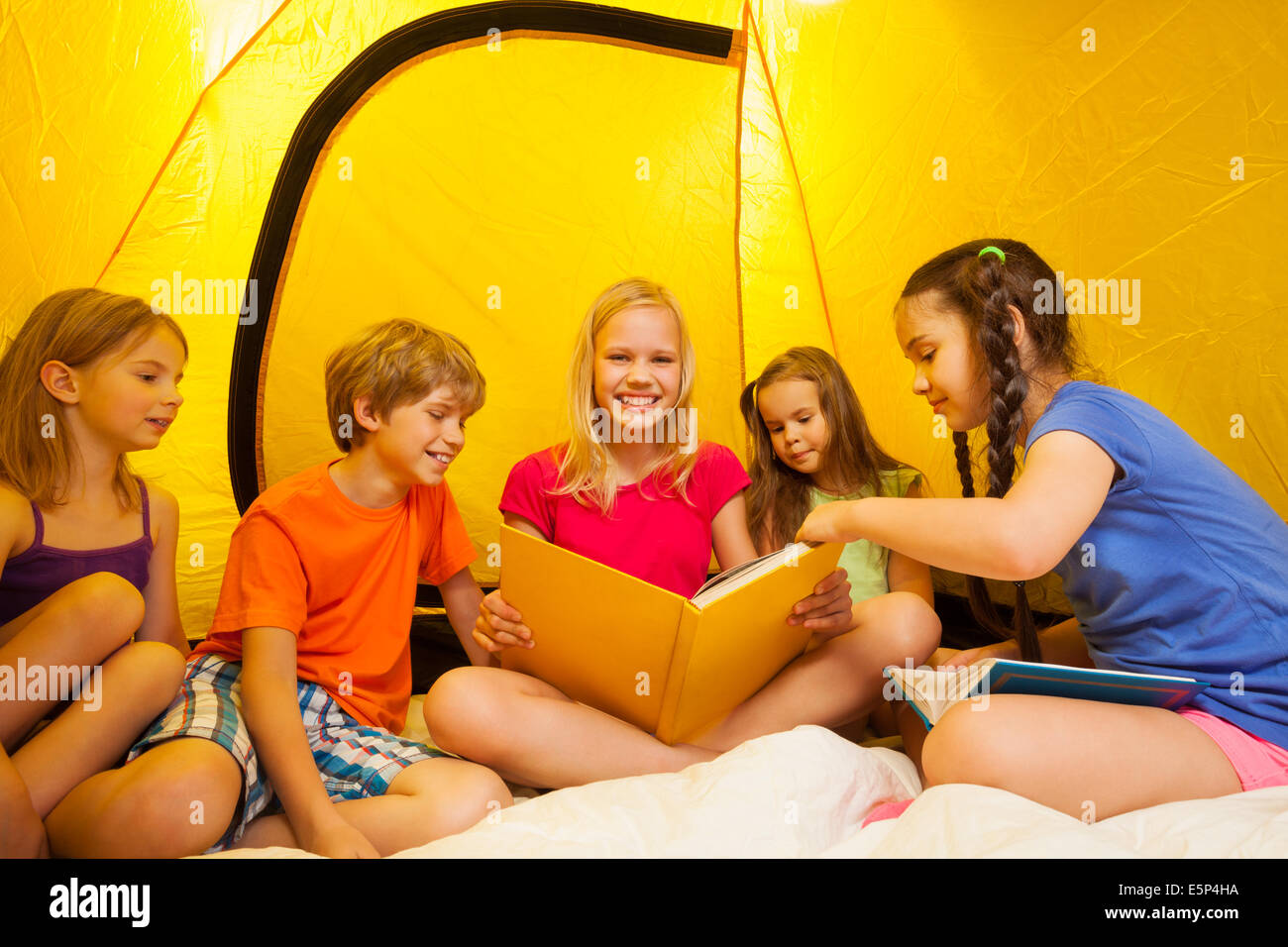 Five funny kids read book in a tent Stock Photo - Alamy