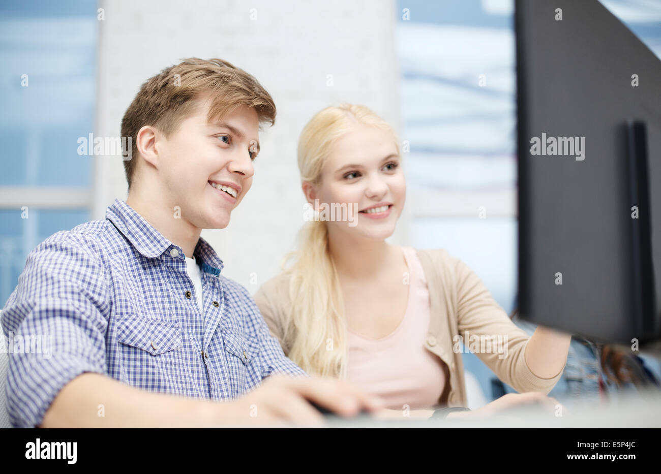 smiling teenage boy and girl in computer class Stock Photo - Alamy